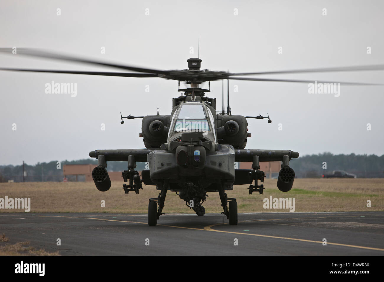 AH-64 Apache helicopter sits on the runway during flight operations ...