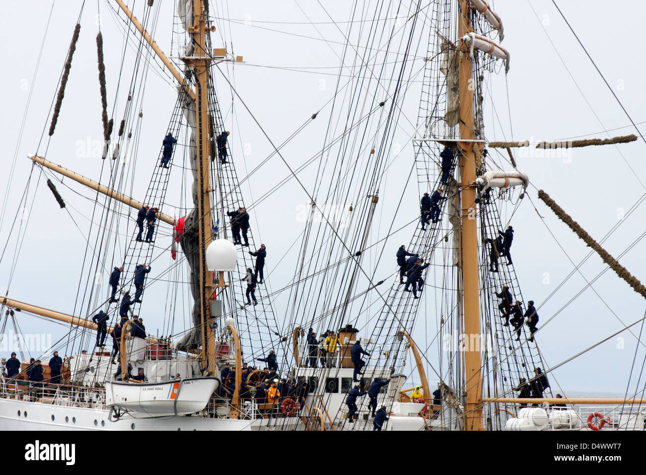 Sailors climbing rigging of US coastguard vessel during Tall ships ...