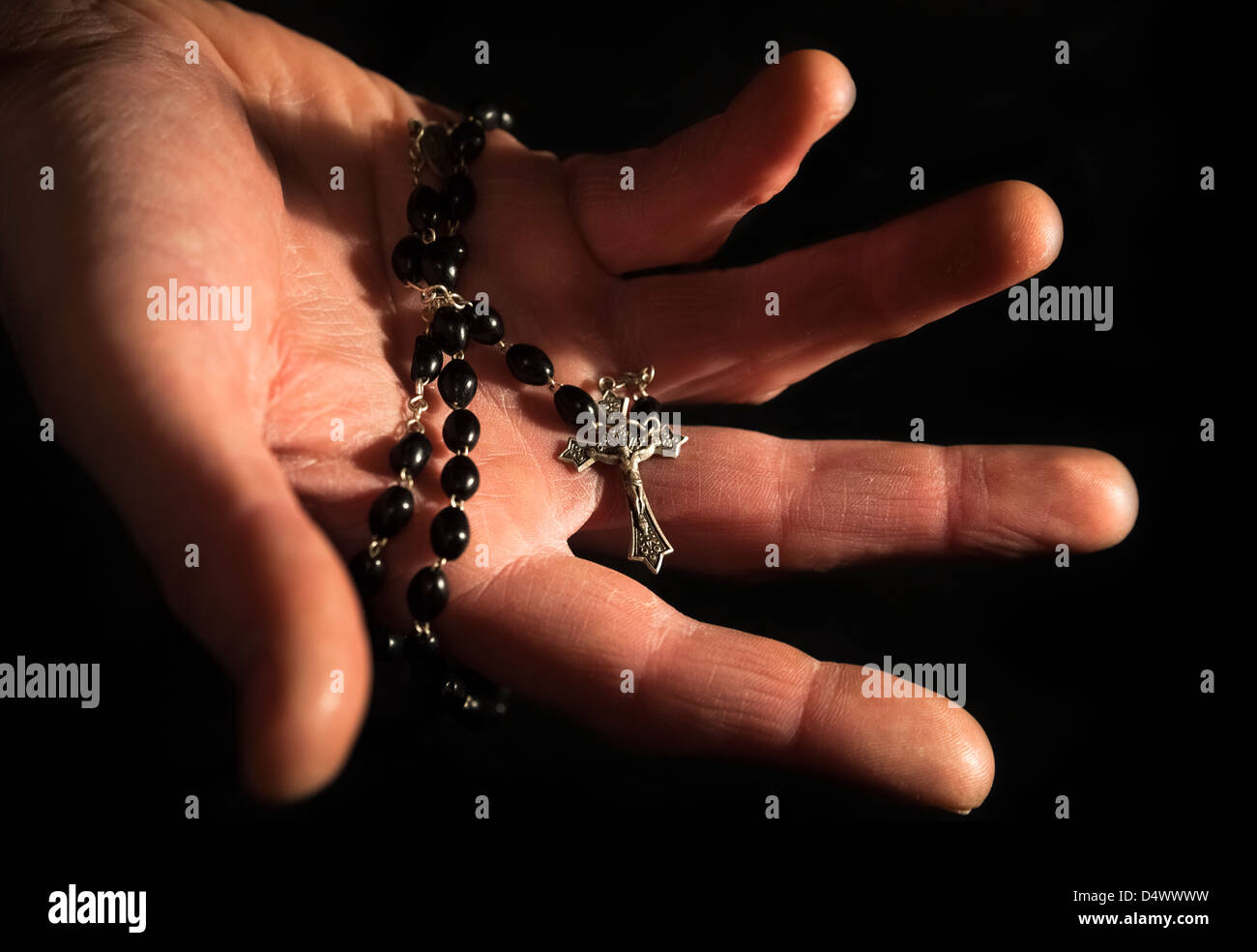 Helping hand holding onto rosary beads and cross Stock Photo - Alamy