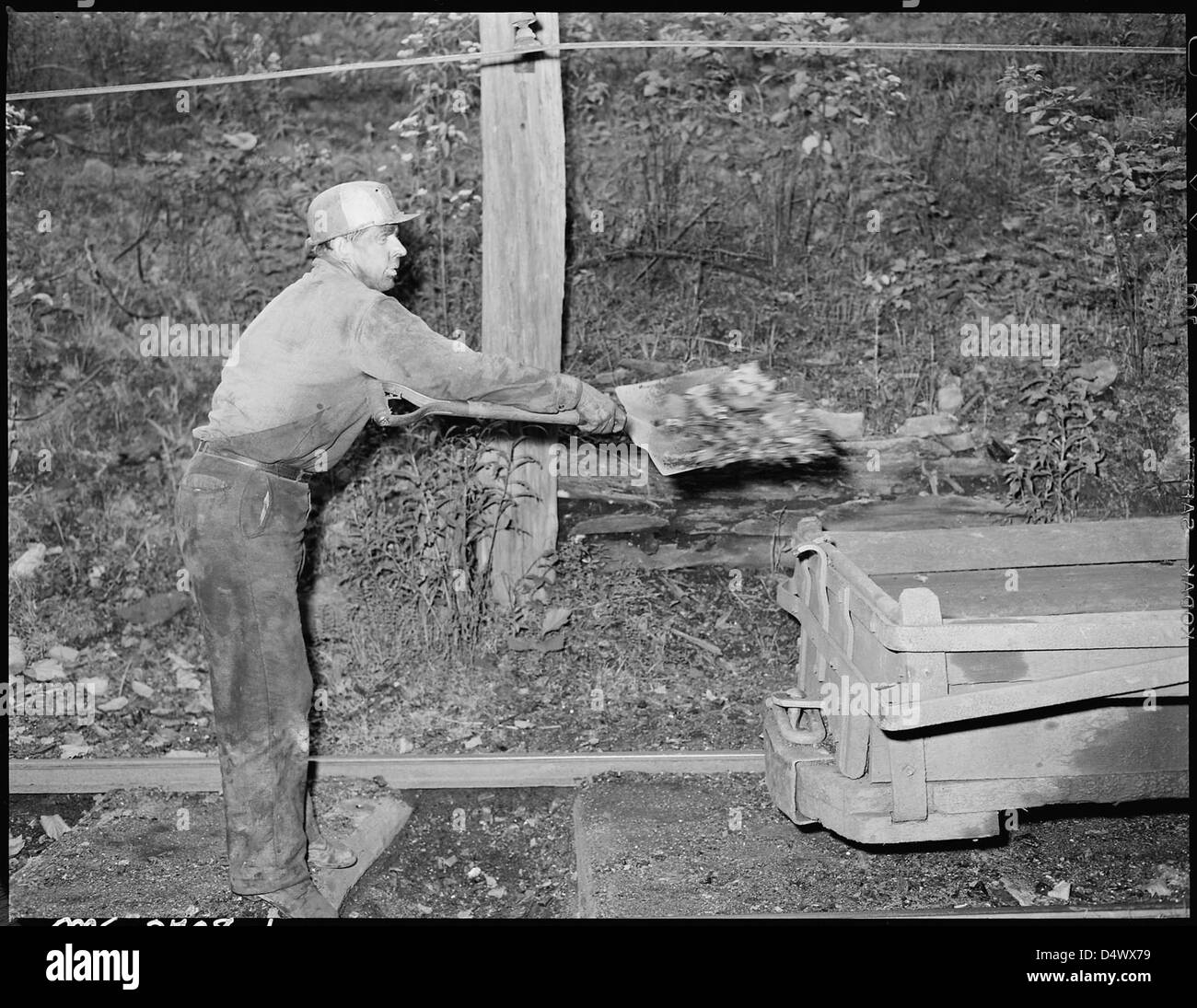 Eli Sanders, a coal miner, loads coal onto a car after it fell off en ...