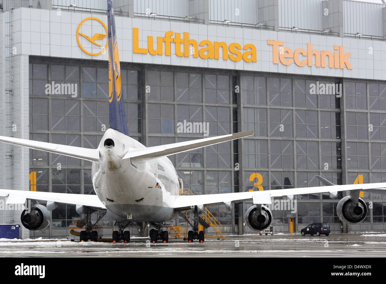 A Boeing 747-400 is parked in front of the large jumbo hangar at ...