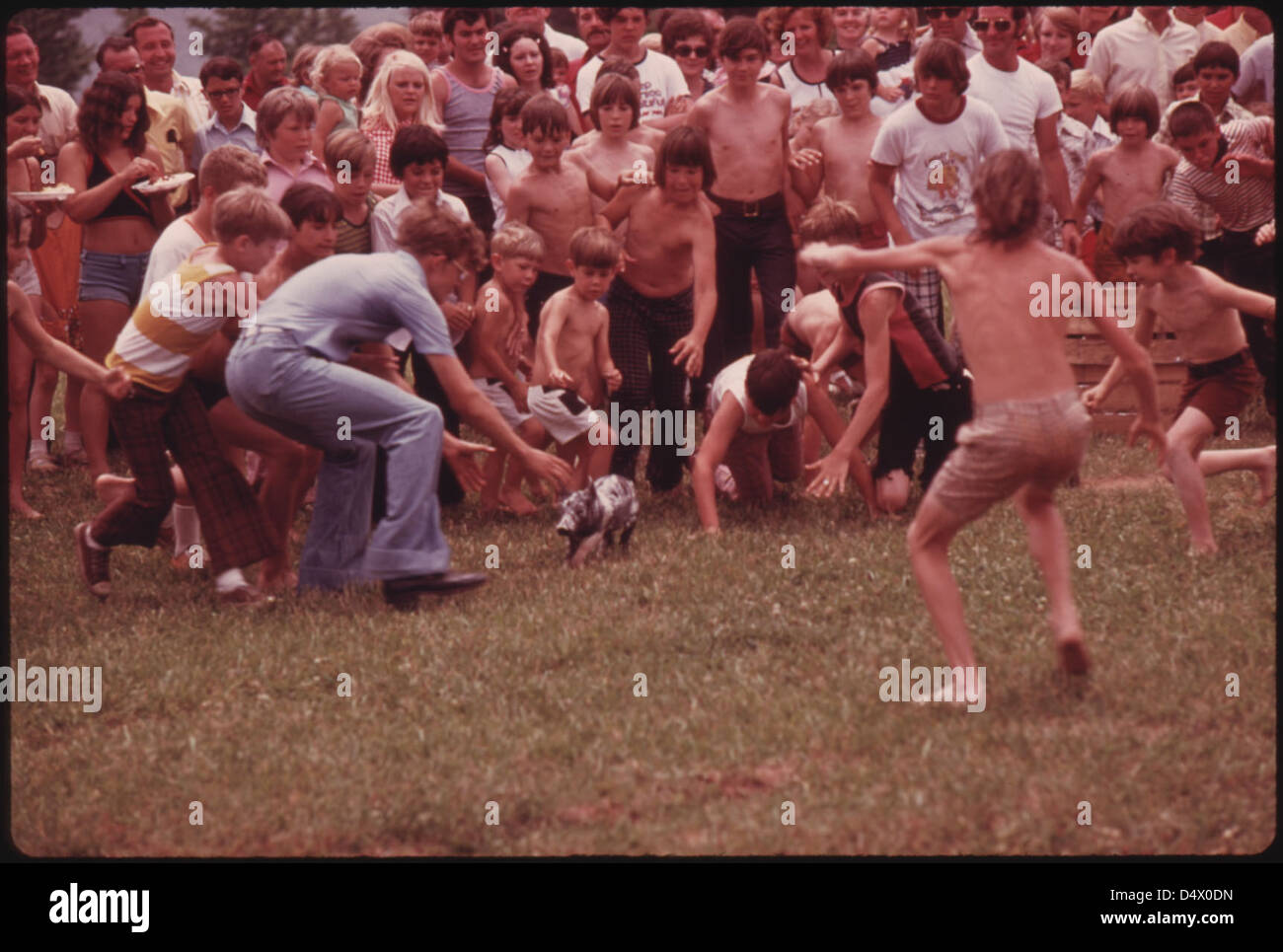 A photograph from August 1974 showing children in a greased pig contest ...