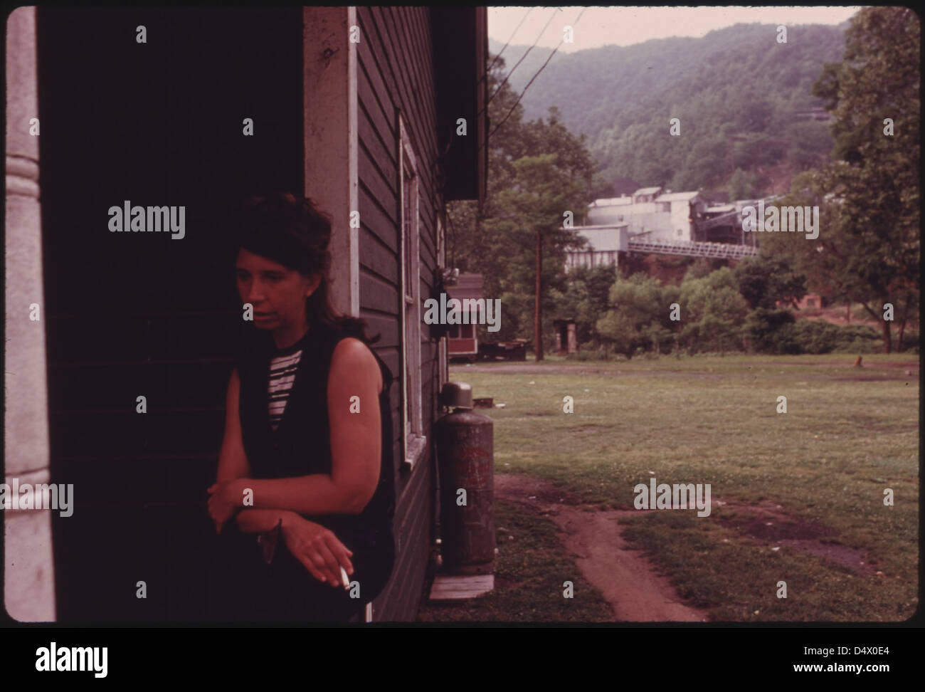 Nannie Rainey, wife of miner Jerry Rainey, stands outside company-owned ...