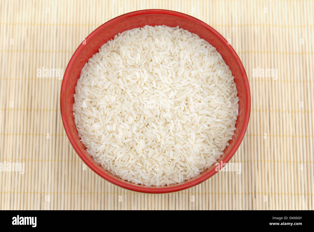 White rice in red bowl on bamboo background Stock Photo - Alamy