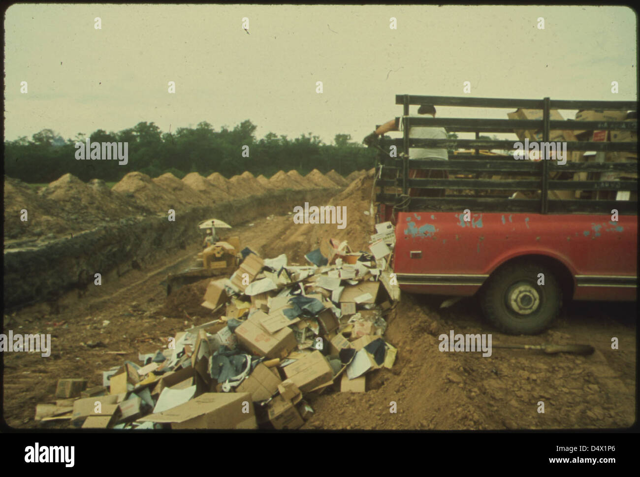 A 1972 photo showing solid waste being dumped into trenches at a ...