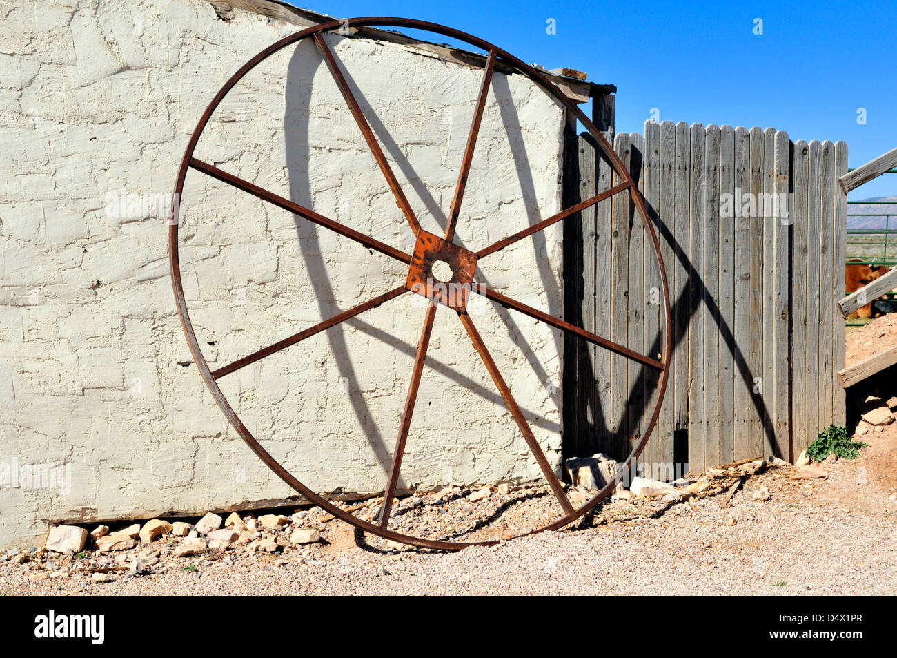 A giant wagon wheel leans against a wall Stock Photo - Alamy