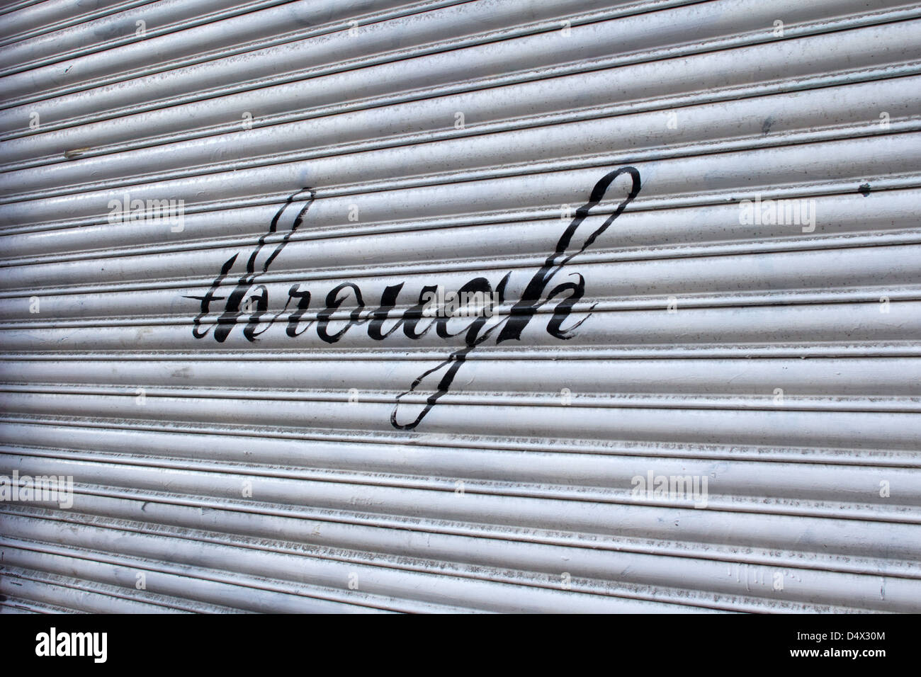 Stencil art of the word 'through', painted on a shop's shutter in ...