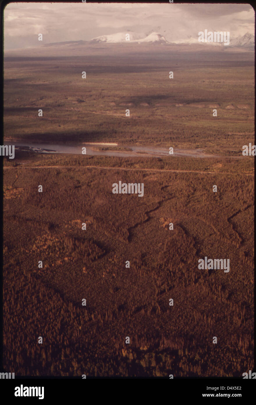 In August 1973, a view northeast across a small lake shows a pipeline ...