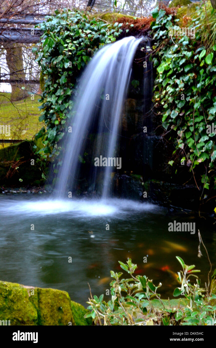 A beautiful waterfall, hid amongst natural foliage and cascading off ...