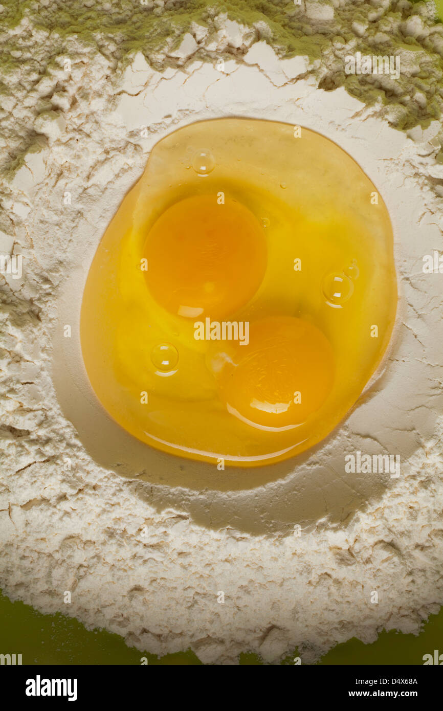 Flour and eggs for pasta formed into a well Stock Photo - Alamy
