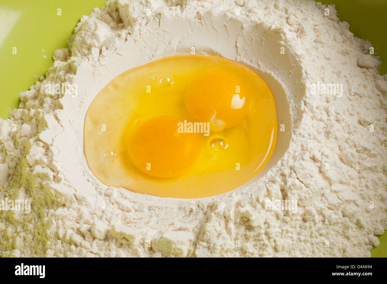 Flour and eggs for pasta formed into a well Stock Photo - Alamy