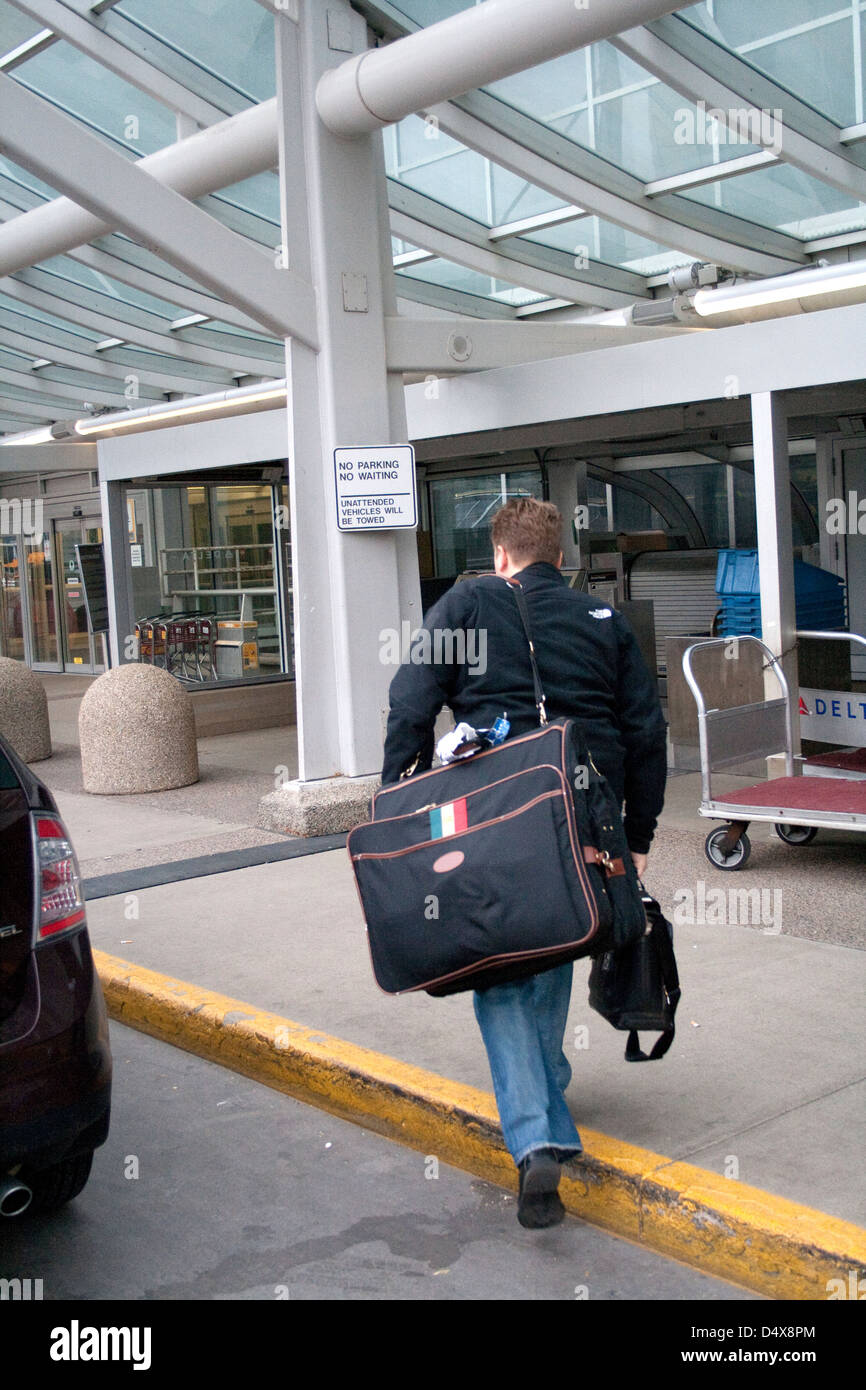 Passenger with carry-on baggage walking toward Minneapolis-St Paul ...