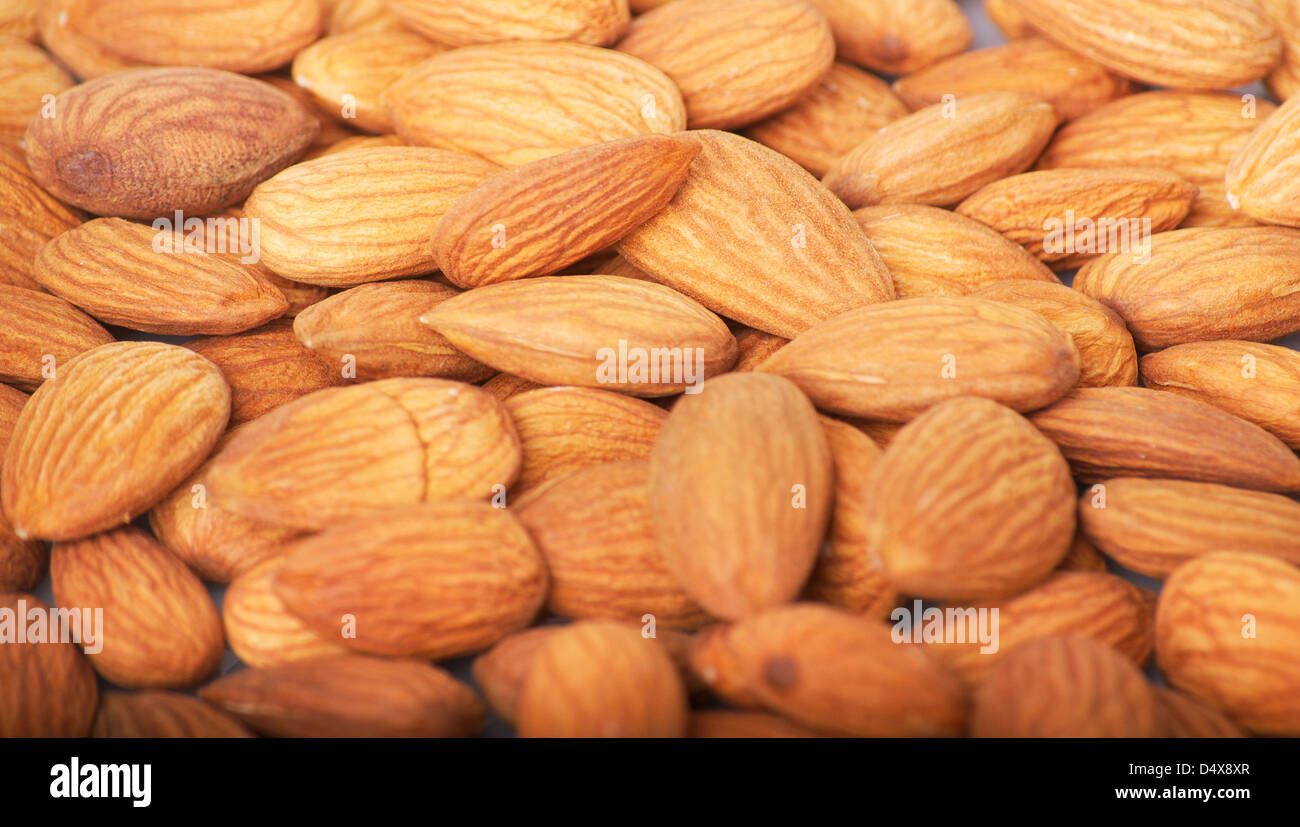 Pile of almonds close-up as background Stock Photo - Alamy