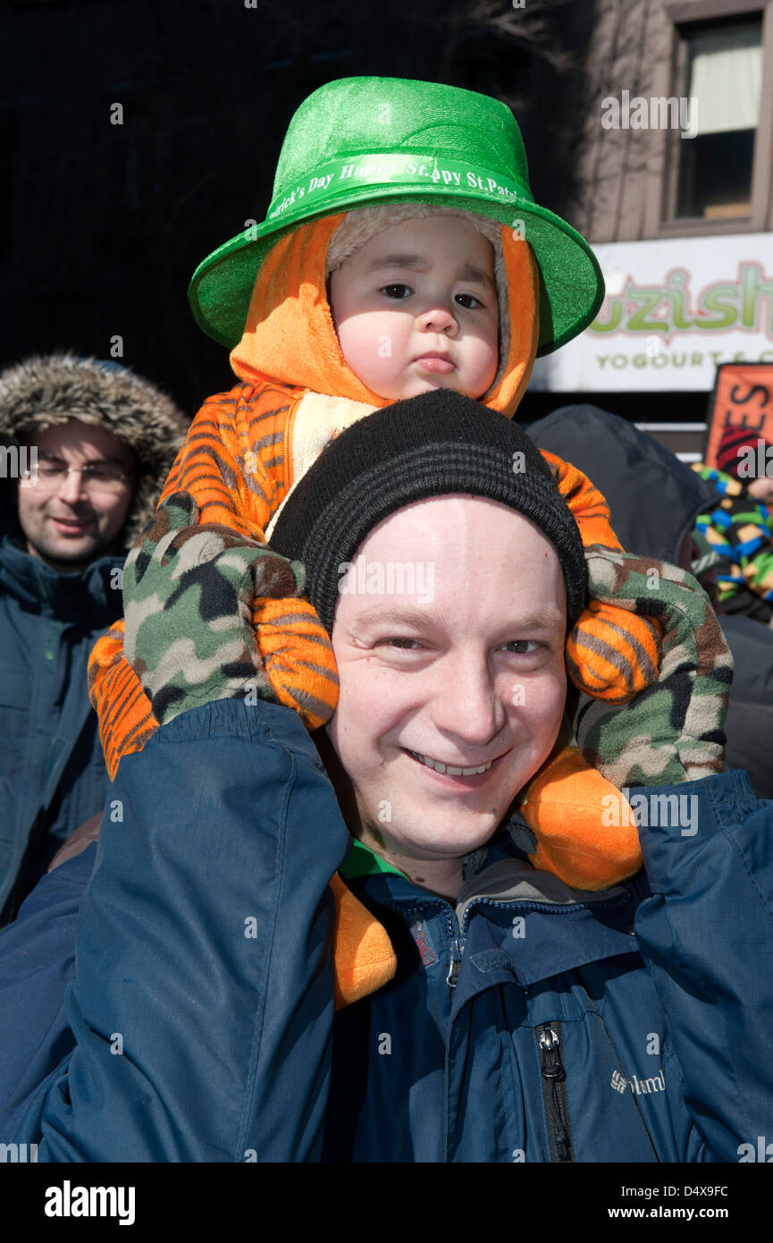 Child on the shoulders of a man attending the St Patrick's day parade ...