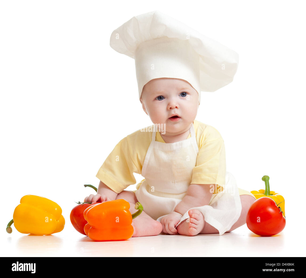 Portrait of a baby wearing a chef hat with healthy food vegetables ...