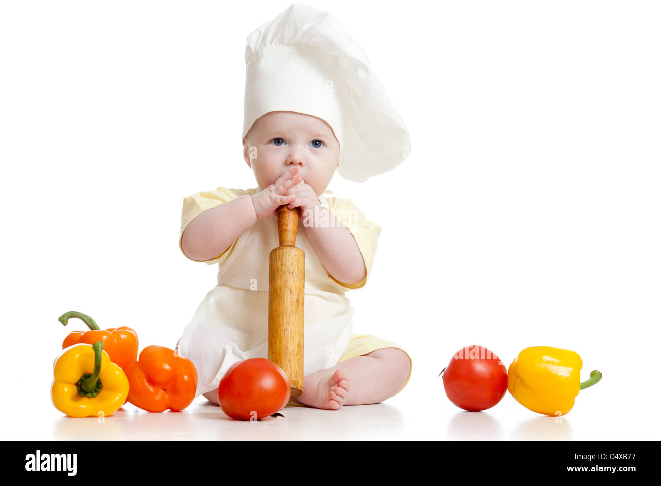 Portrait of a baby wearing a chef hat with healthy food vegetables ...