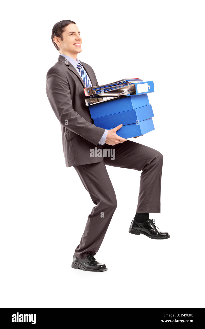 Full length portrait of a young businessman carrying heavy folders ...