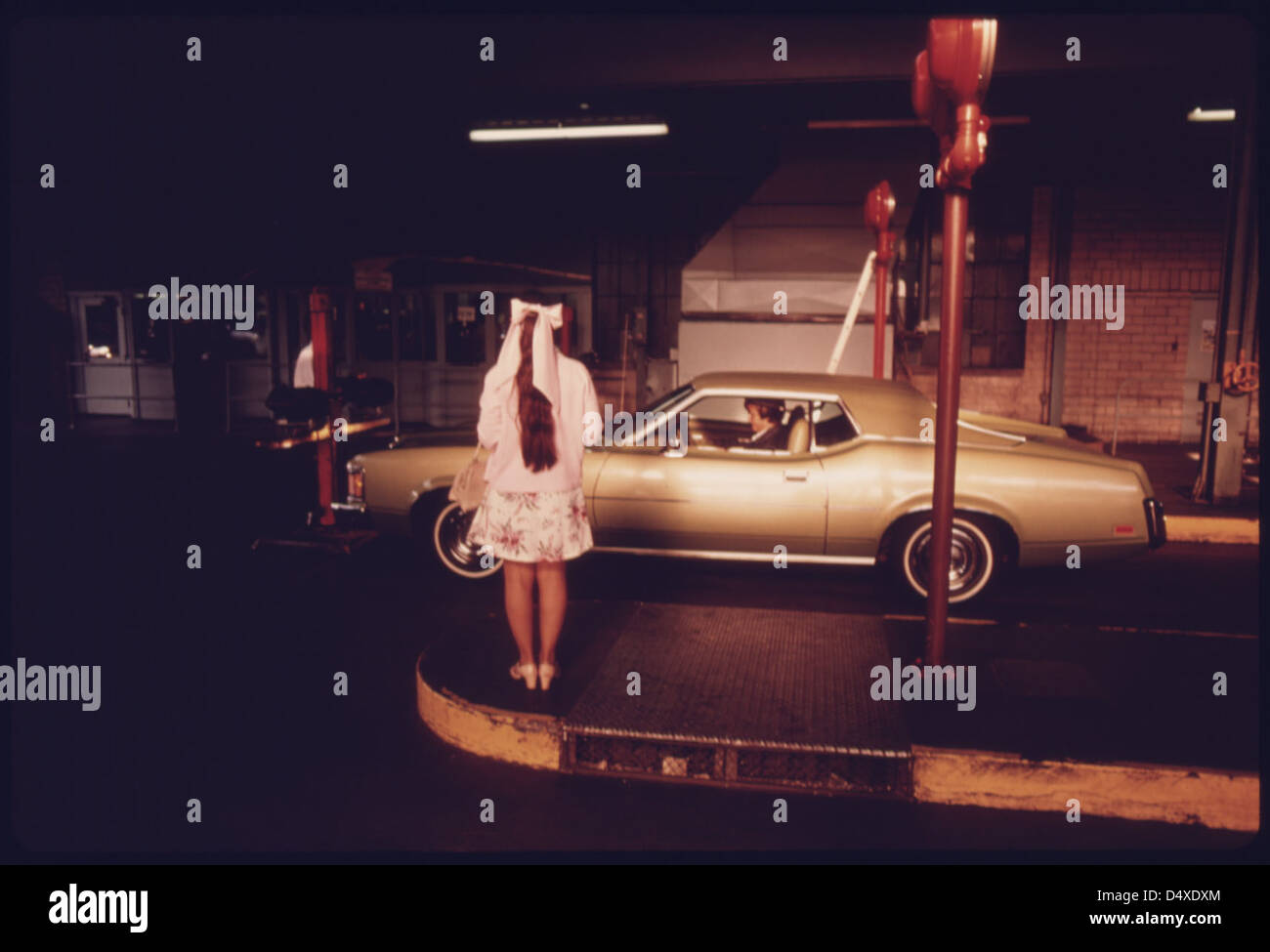 A woman waits for her car to finish an emissions inspection at an auto ...
