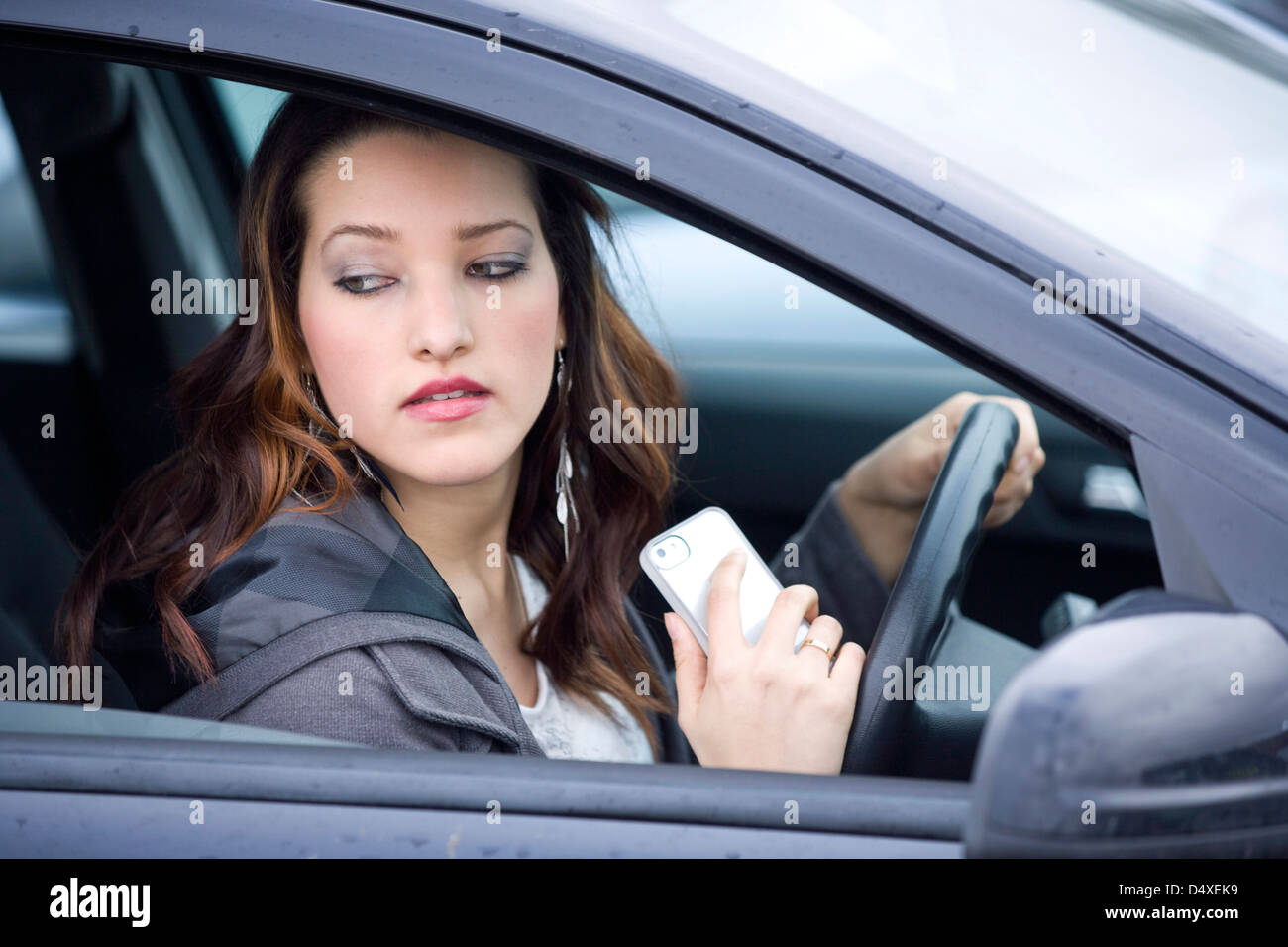 Woman holding a mobile phone while driving Stock Photo - Alamy