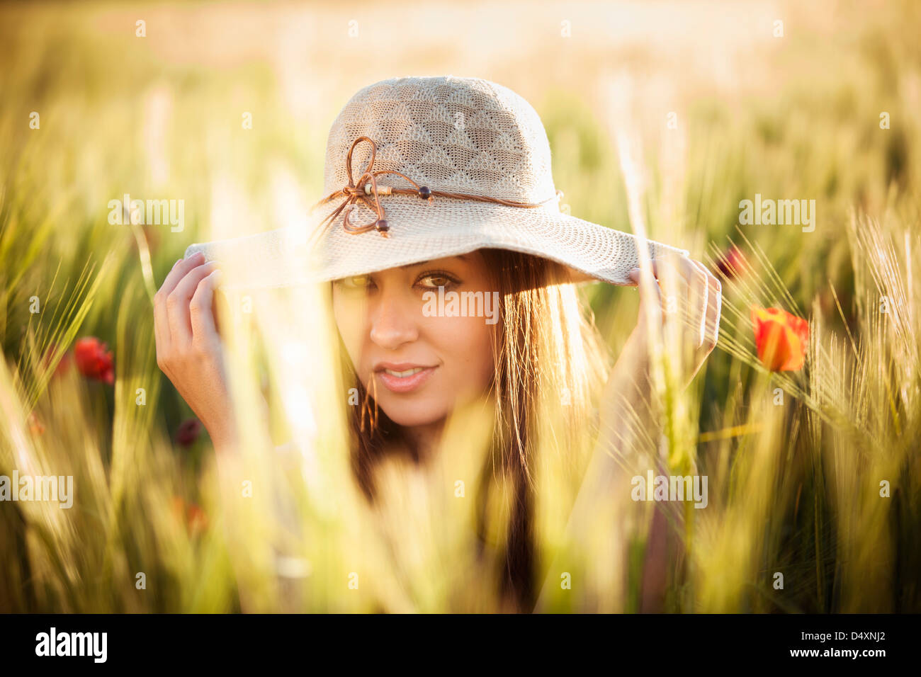 Young beautiful girl posing in a green field Stock Photo - Alamy