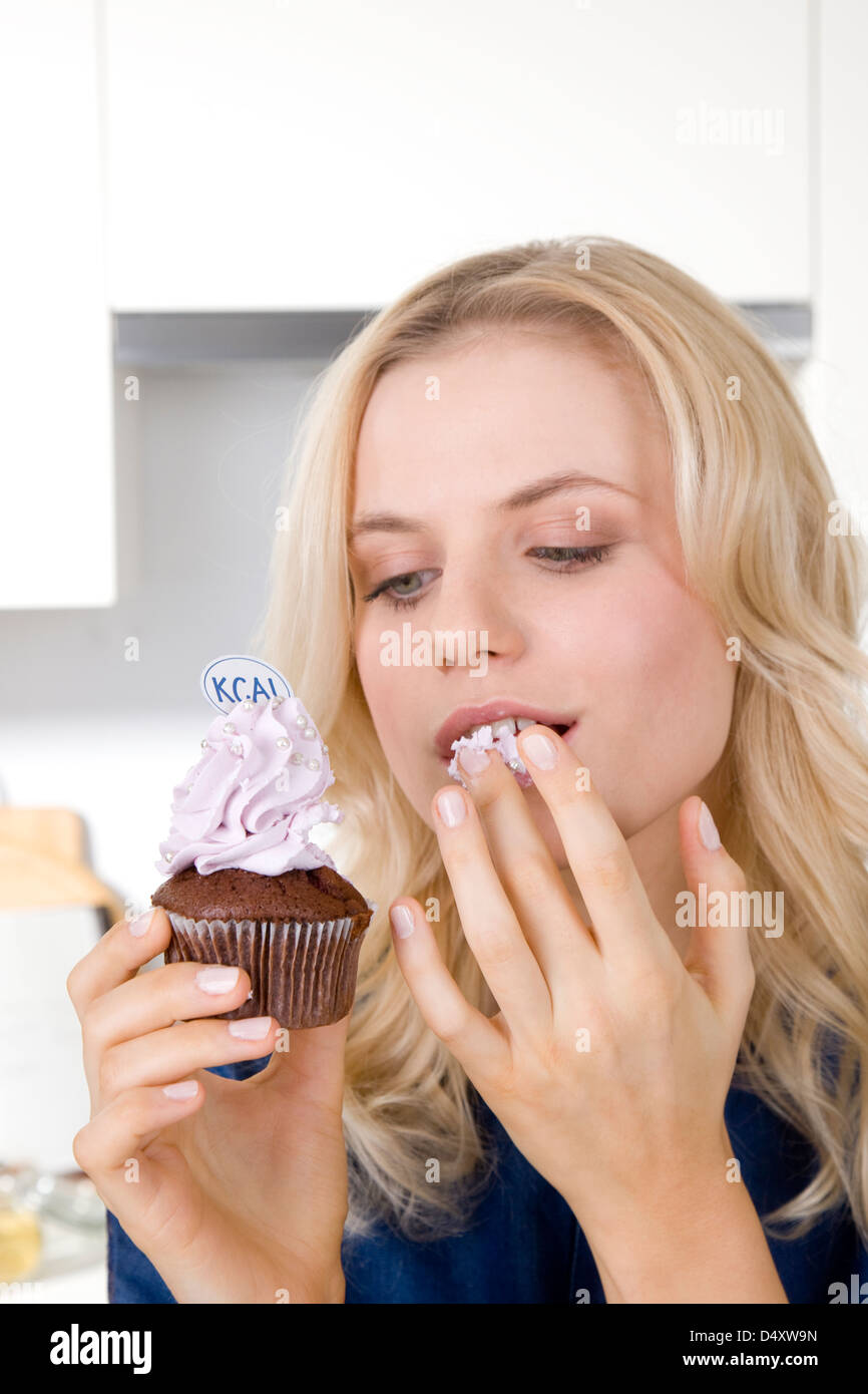 Woman eating cupcake with cream Stock Photo - Alamy