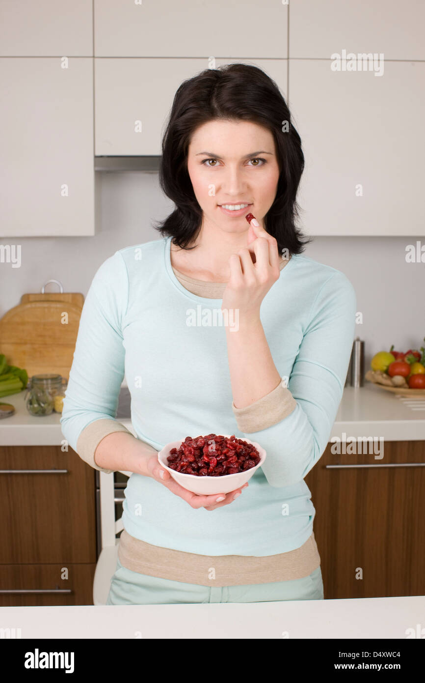 Woman eating dried cranberries Stock Photo - Alamy