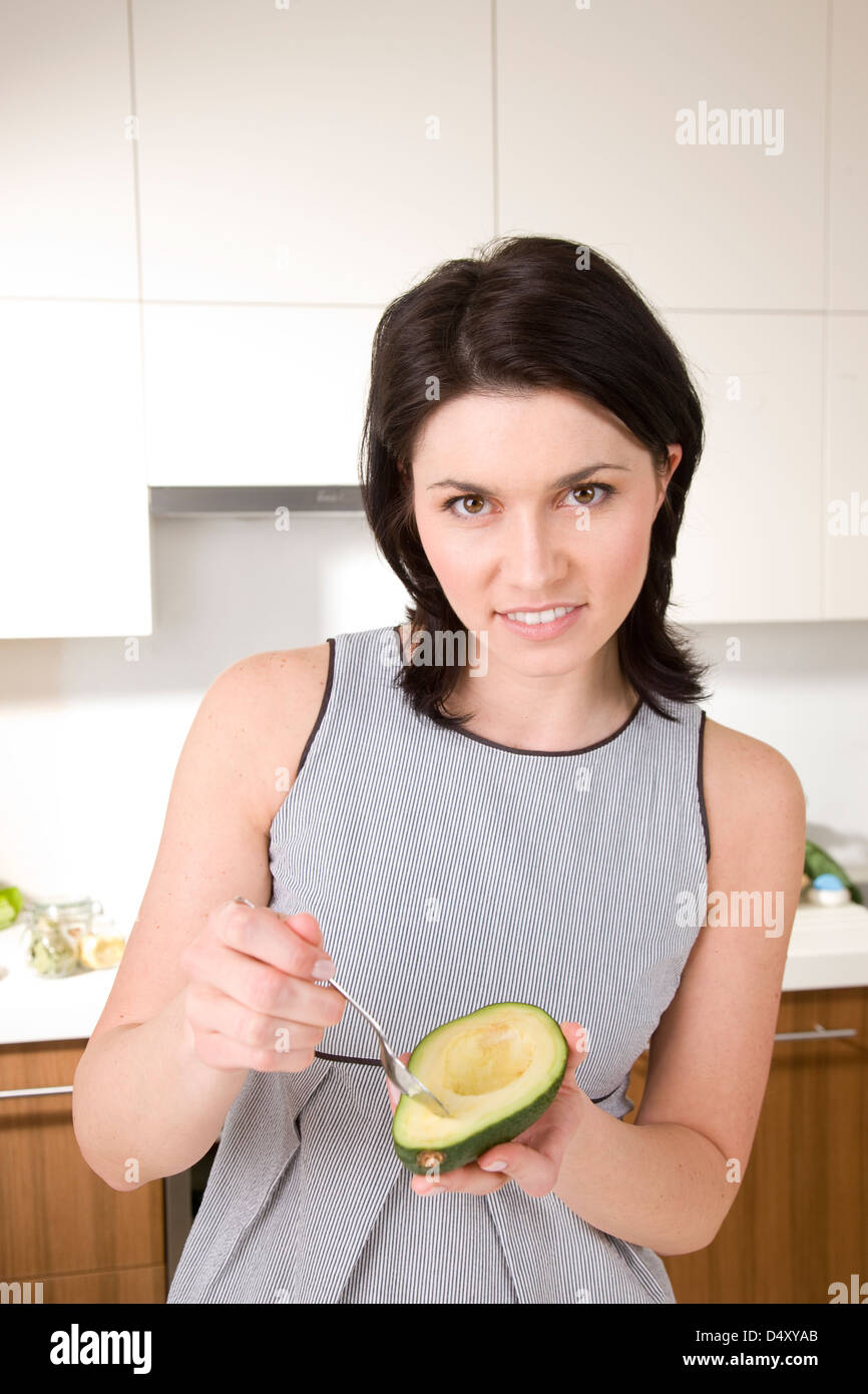 Woman eating avocado Stock Photo - Alamy