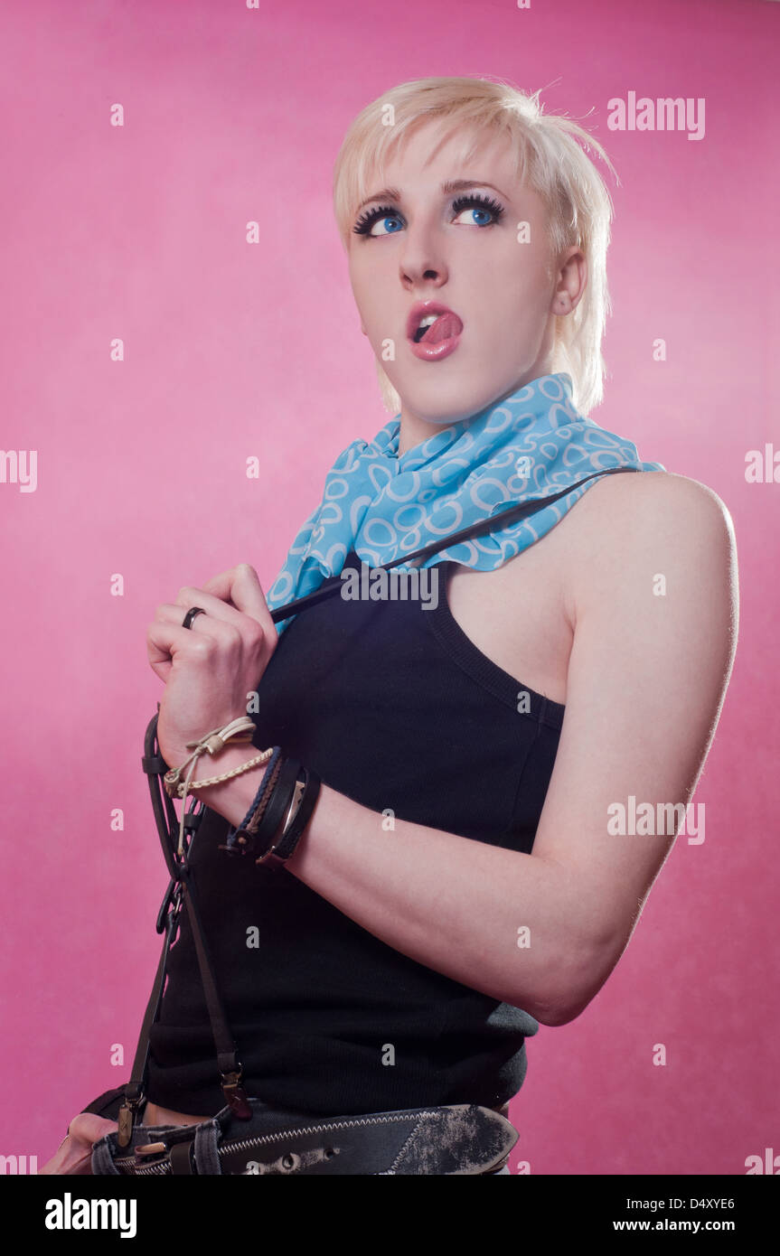 the fair-haired young man with a make-up on a face on a pink background ...