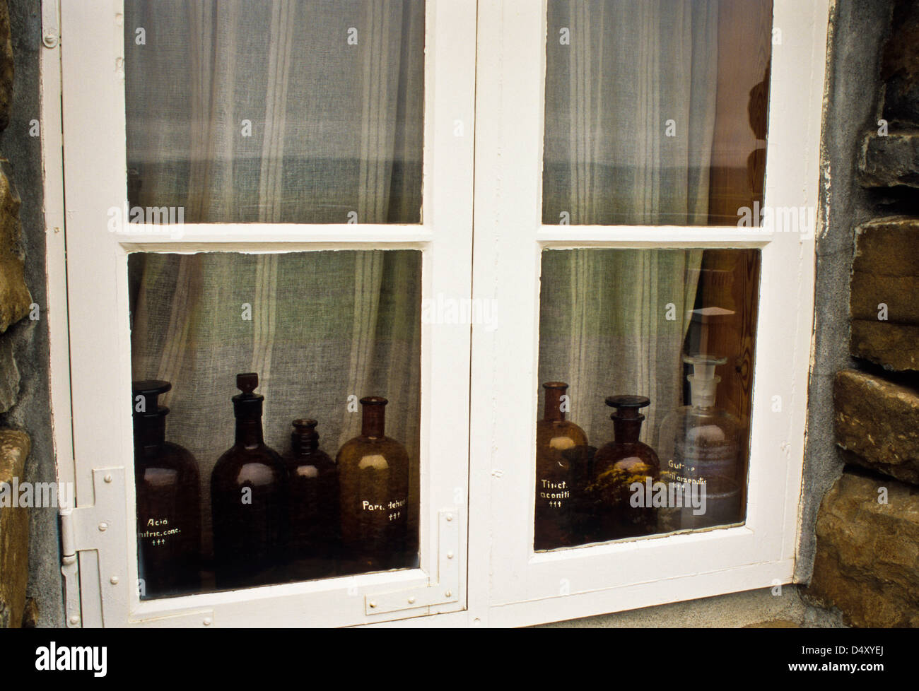 White window sill exterior with antique brown pharmacy medicine bottles ...