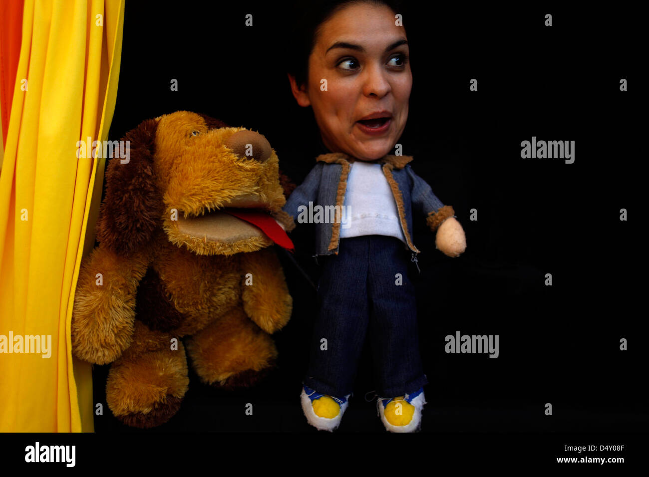 An actress dressed as a boy holds a teddy bear dog during a puppet show ...