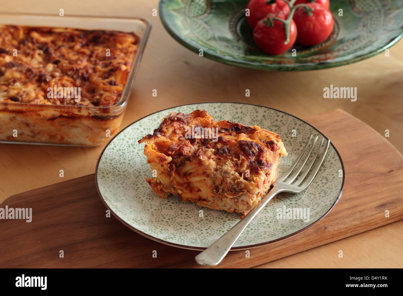 Baked dish and slice of lasagne with tomatoes, cheese and minced beef ...
