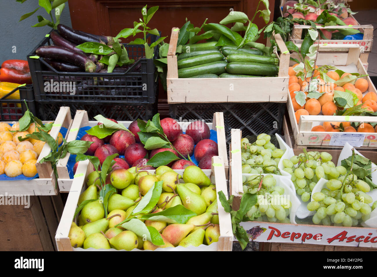 Close up of fresh fruit & vegetables displayed in wooden crates outside ...