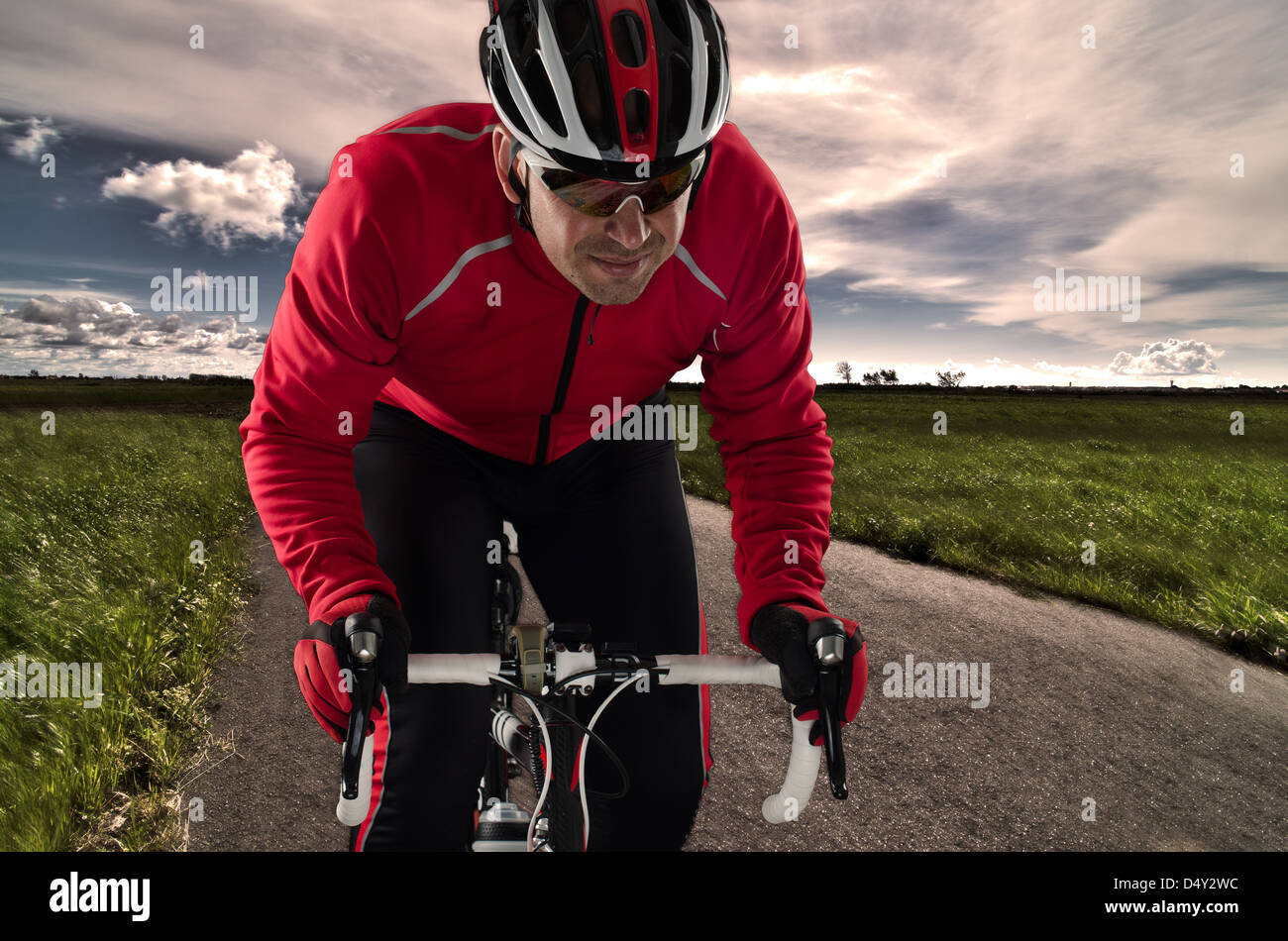 Cyclist on road bike through a asphalt road and blue sky with clouds ...