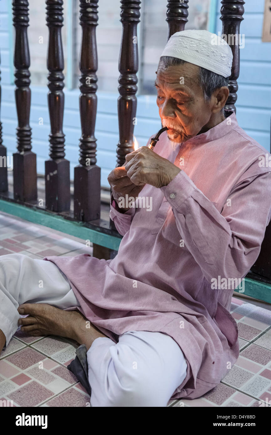 Old muslim man smoking on a pipe, Kampung Ayer neighbourhood, Bandar ...