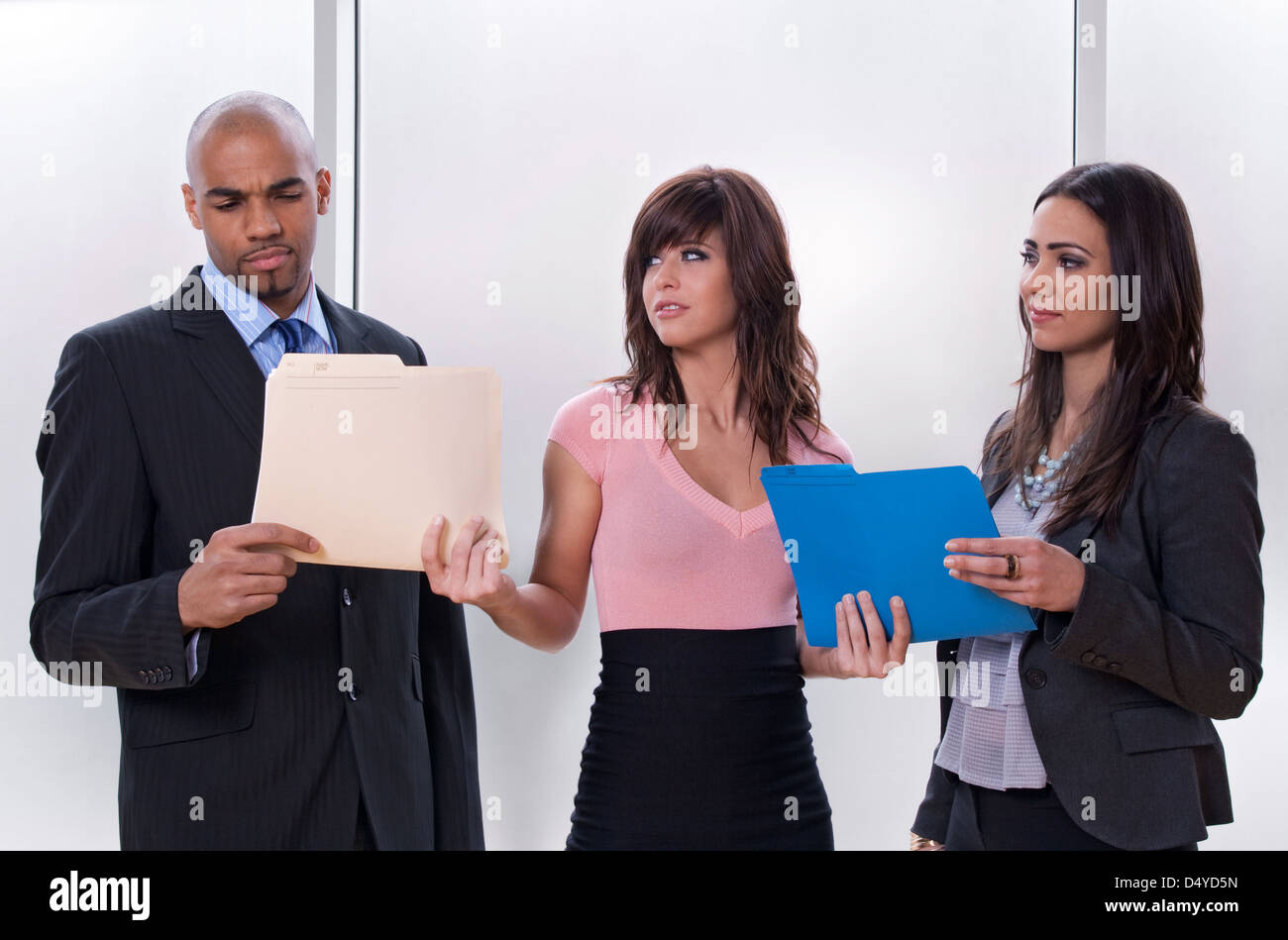 Young woman giving tasks to her colleagues who look skeptical Stock ...