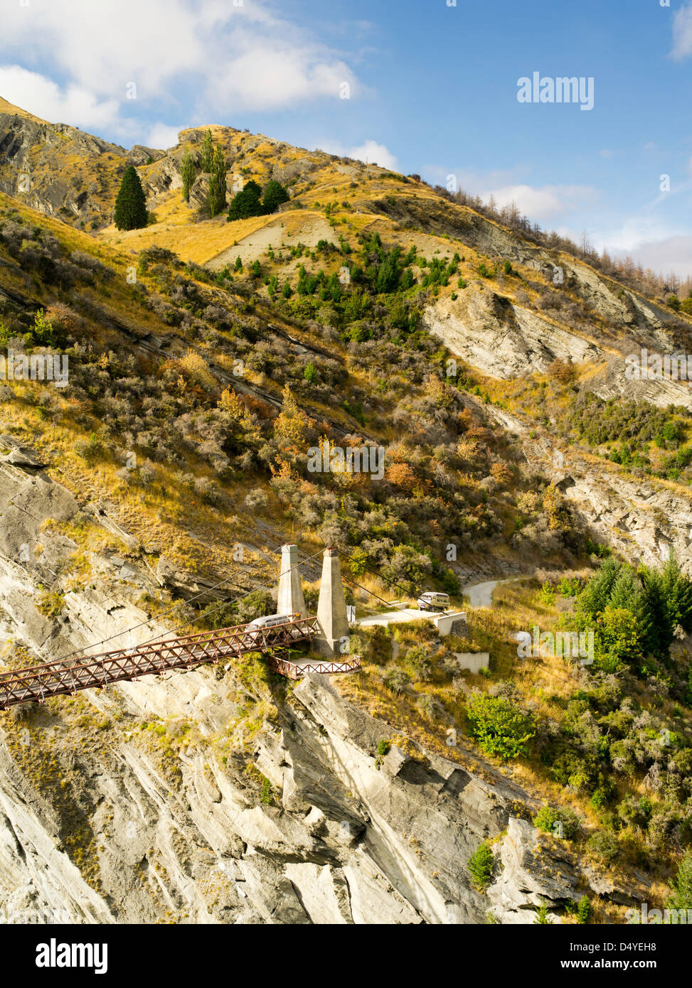 Two tourist buses from Queenstown Heritage Tours cross an old ...