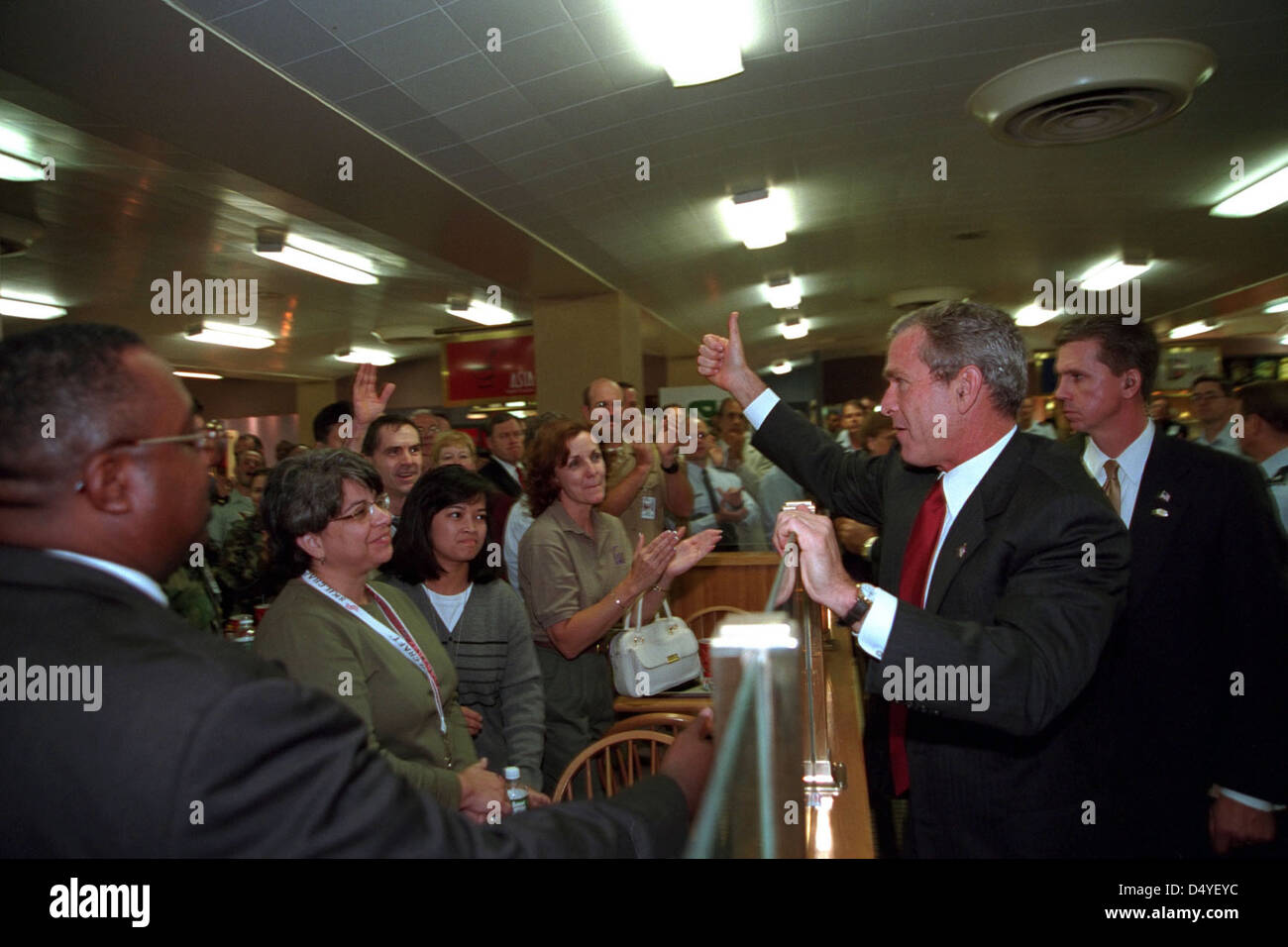 President George W. Bush gives a thumbs-up gesture to employees at the ...