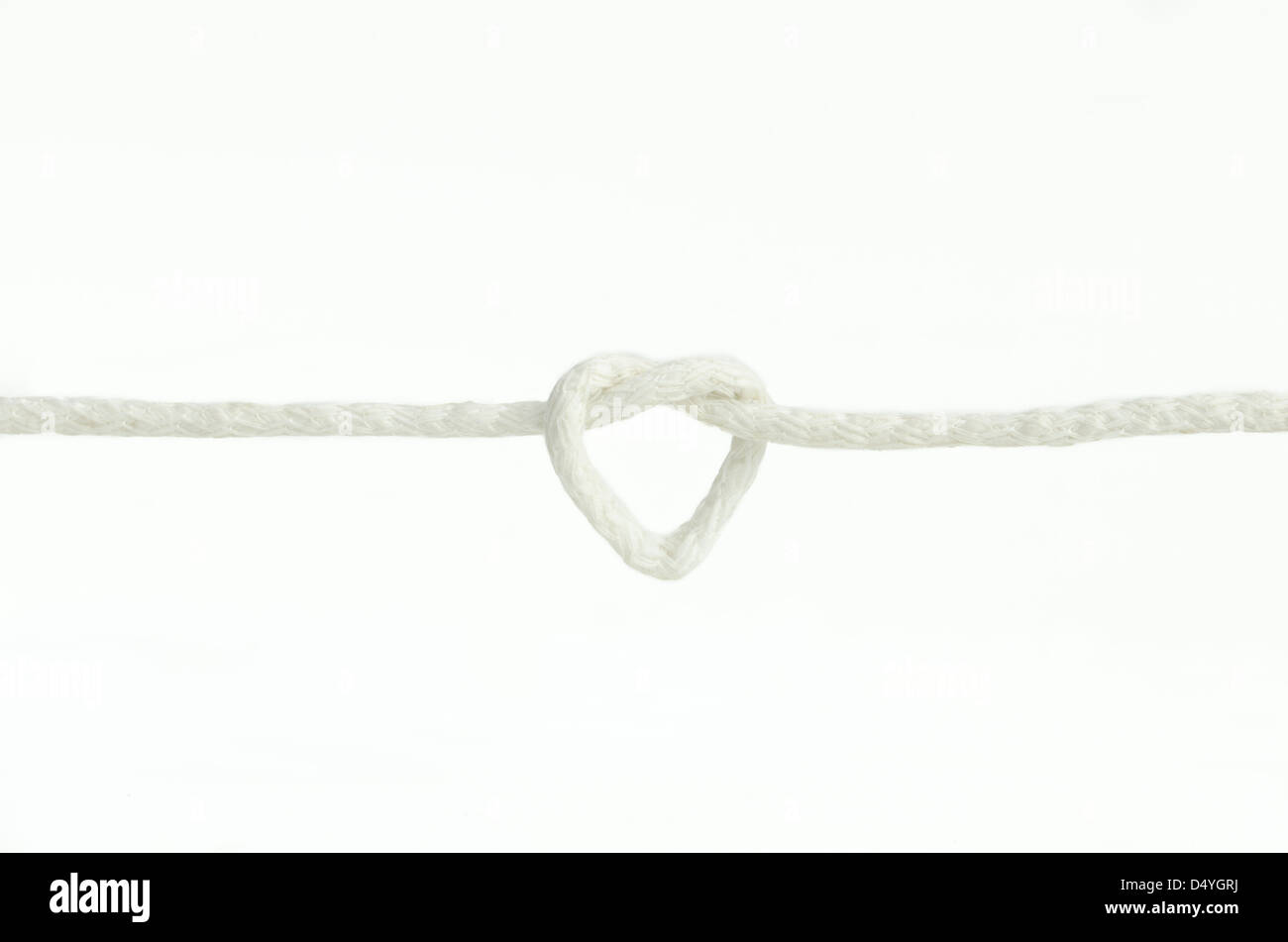 white rope tied in heart shape love knot isolated Stock Photo - Alamy