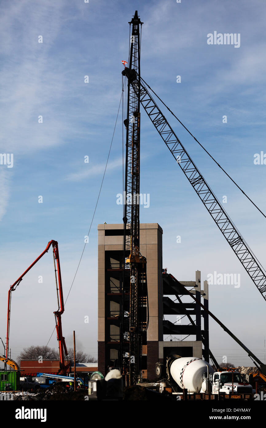 Construction site showing crane, pile driver, and concrete pumper boom ...