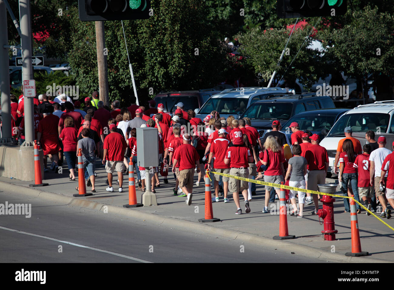 Nebraska Cornhuskers fans walking on street sidewalk wearing red Stock ...