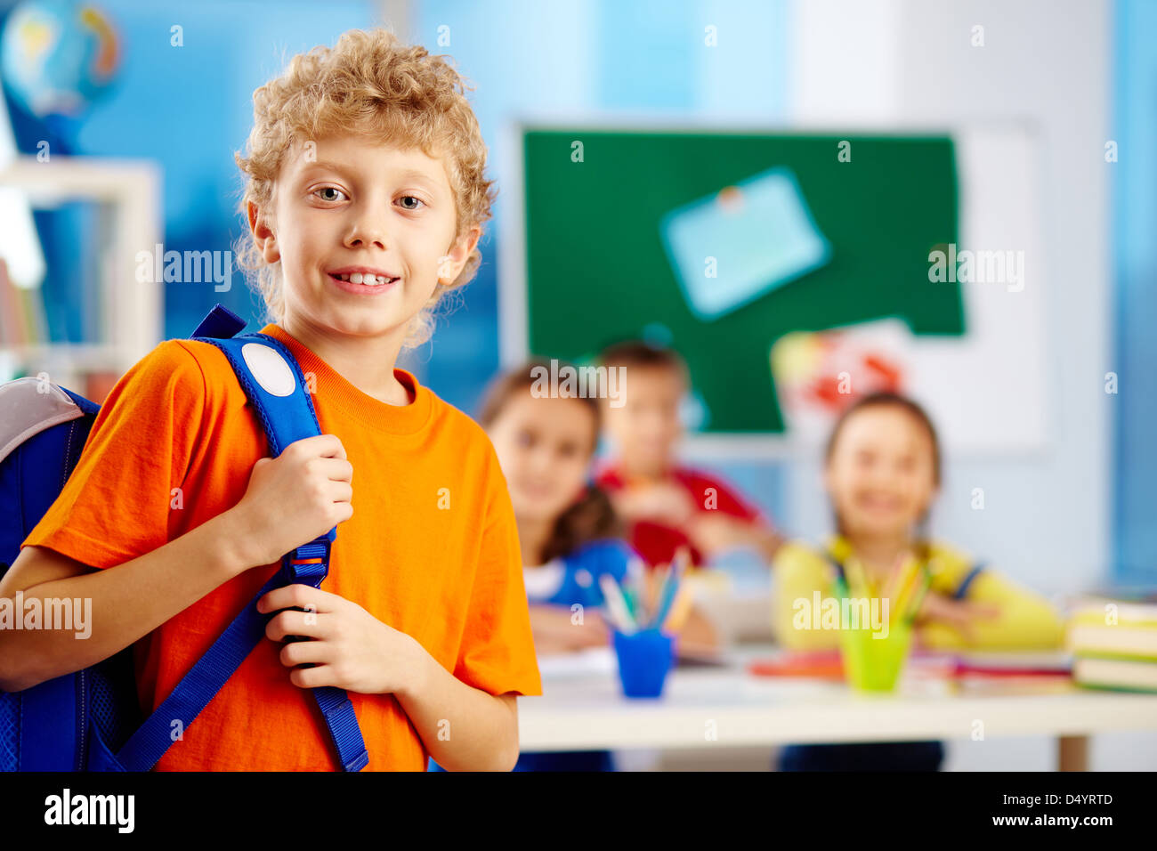 Portrait of cute schoolboy with backpack looking at camera with his ...