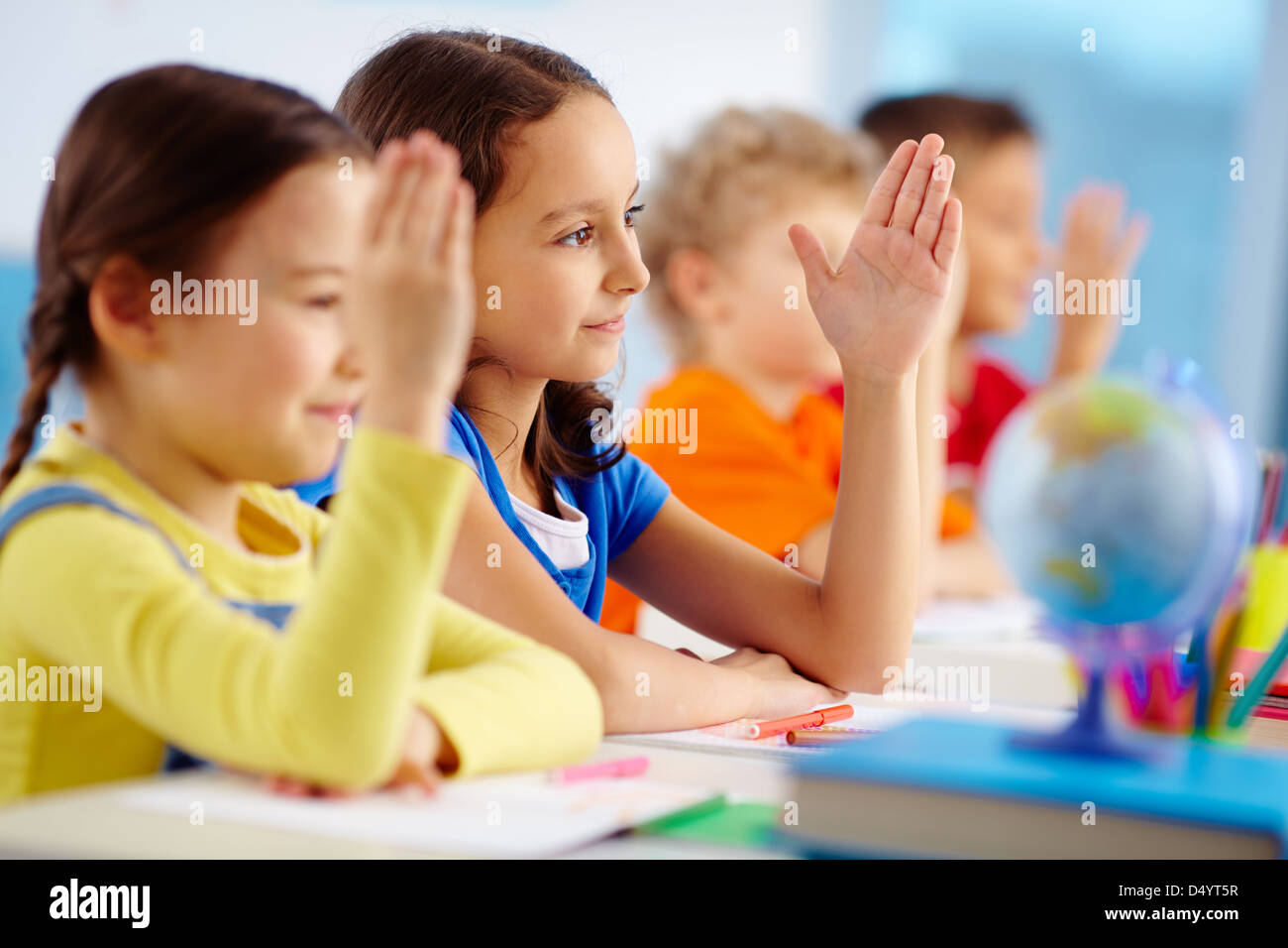 Children raising hands knowing the answer to the question Stock Photo ...