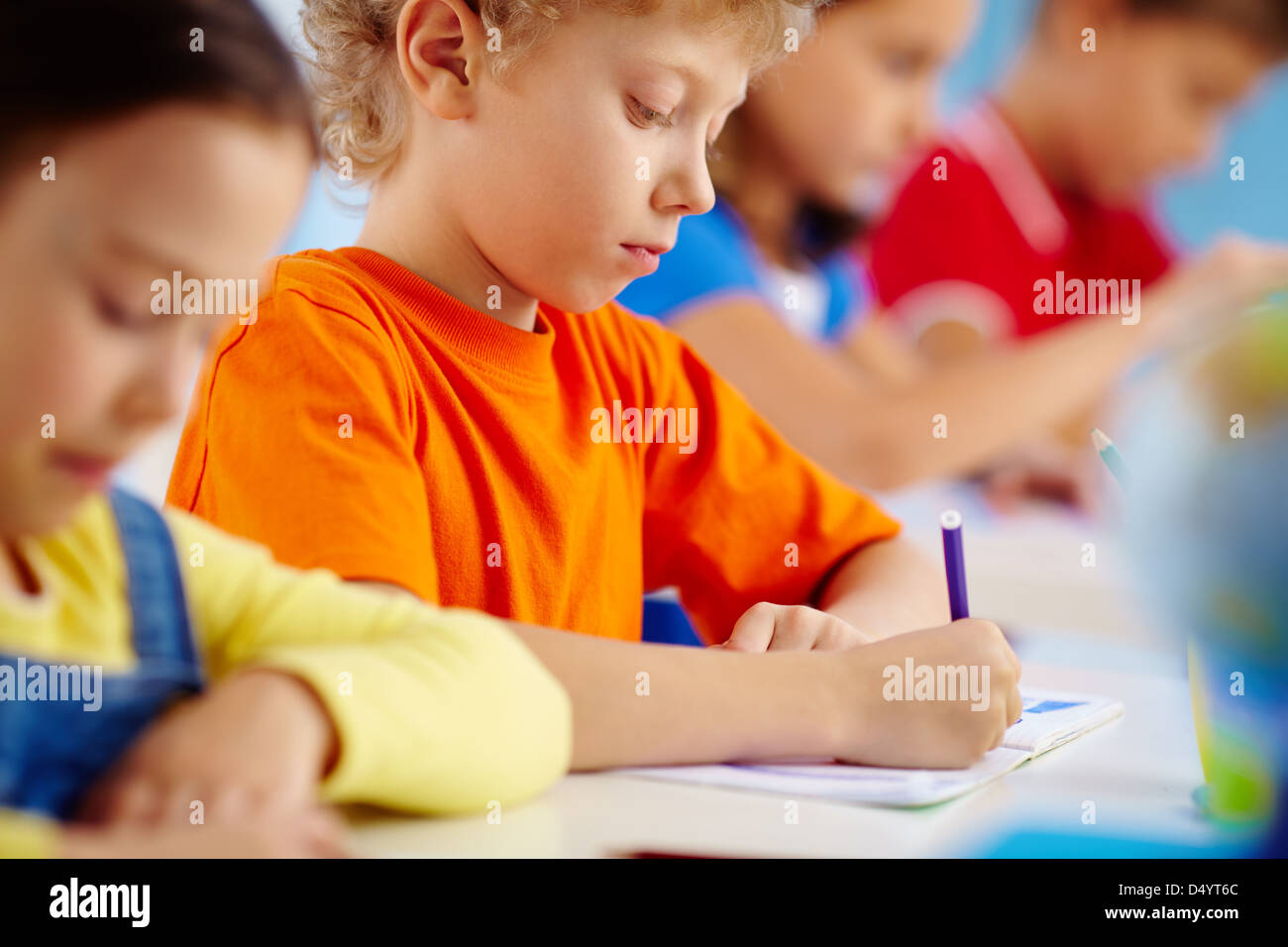Shot of a serious pupil writing in his copybook Stock Photo - Alamy