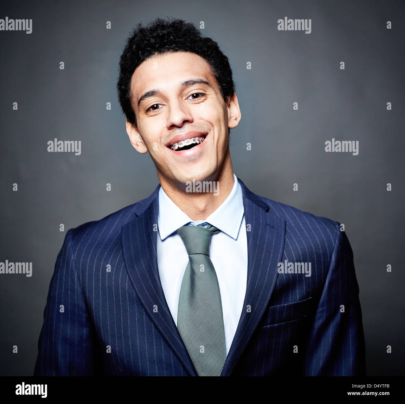 Portrait of a cheerful business guy with braces, against black ...