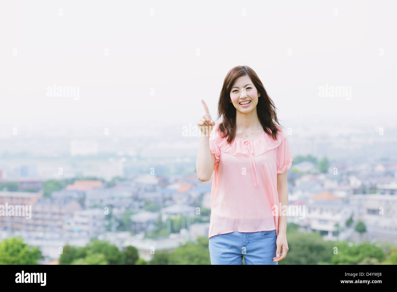 Japanese woman pointing a finger and smiling at camera Stock Photo - Alamy