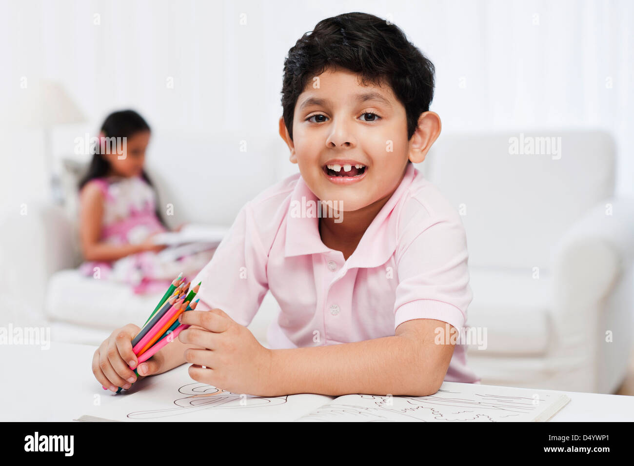 Boy making drawings with his sister in the background Stock Photo - Alamy