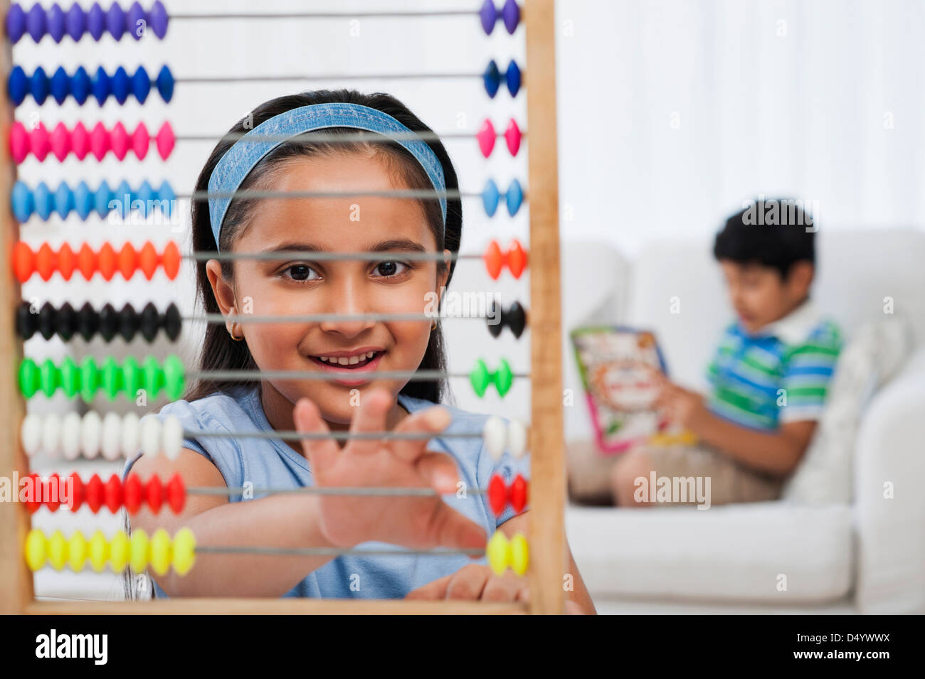 Girl using an abacus with her brother in the background Stock Photo - Alamy