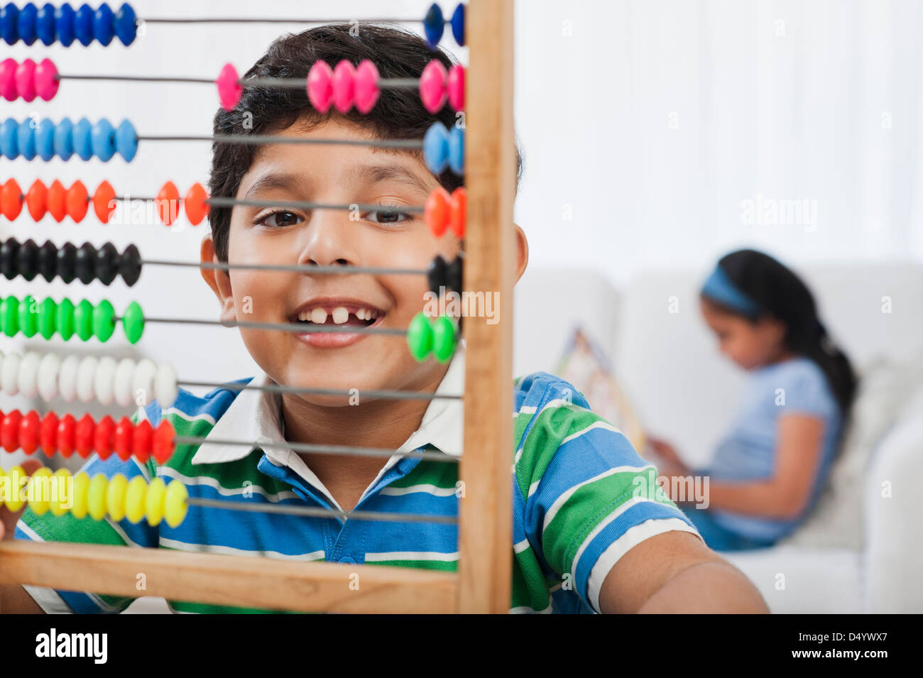 Boy using an abacus with his sister in the background Stock Photo - Alamy