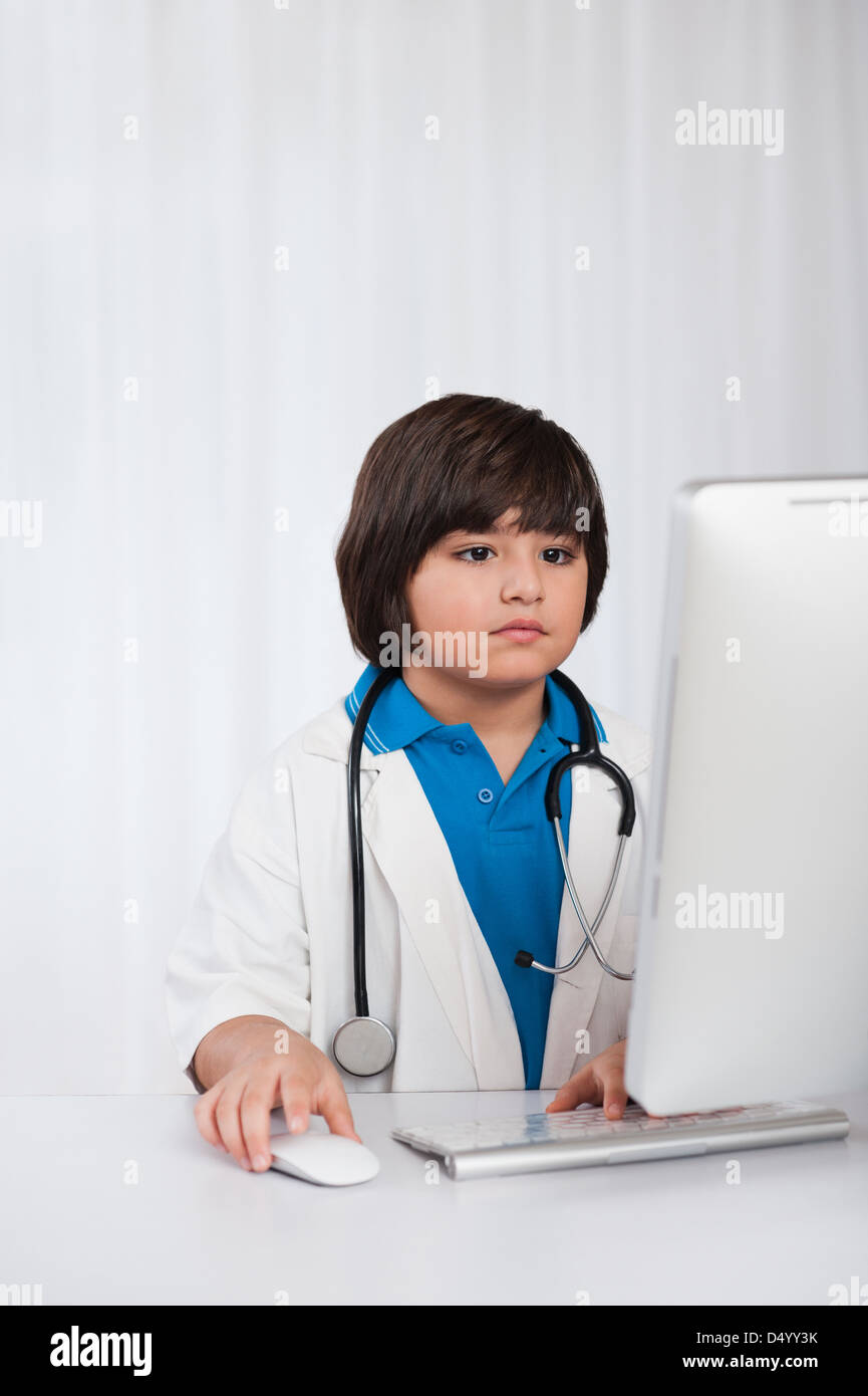 Boy using a desktop computer and imitating like a doctor Stock Photo ...