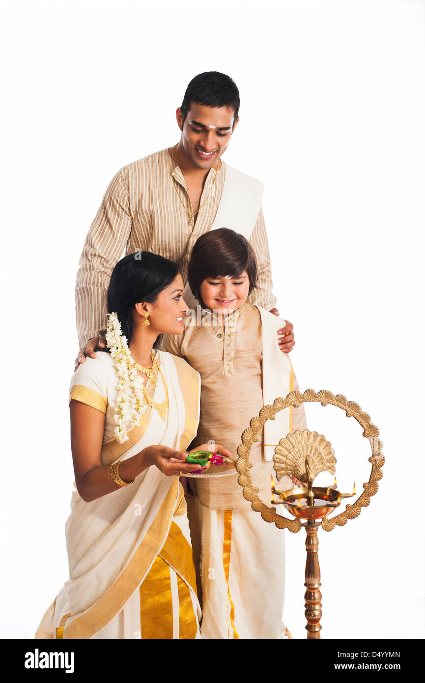South Indian family lighting oil lamp at Onam Stock Photo - Alamy